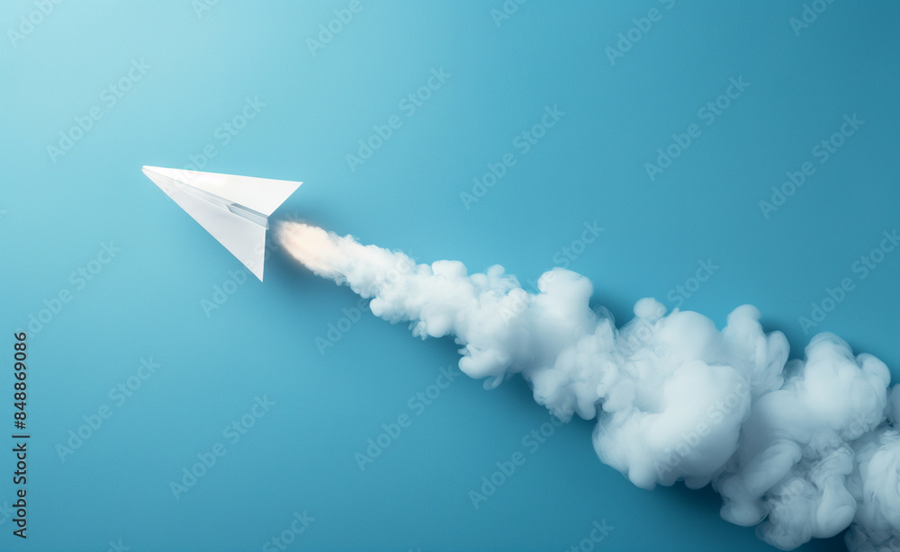 Paper airplane taking off with a trail of clouds on a blue background ...