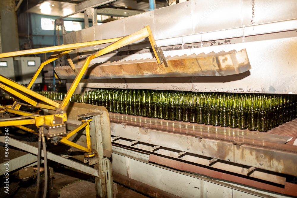 Glass factory, production of glass containers. Molten glass is blown ...
