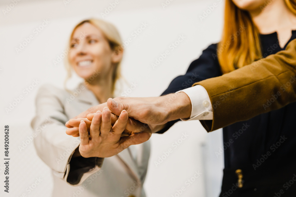 Multiethnic work team put their hands together as a sign of group union ...