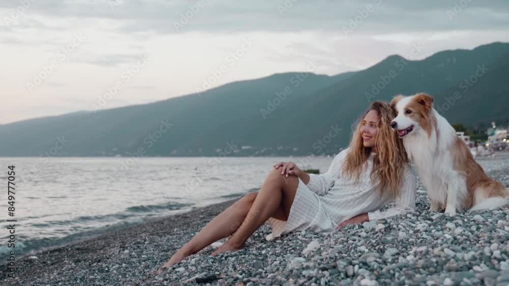 Border collie doggy and woman owner hug caress each other at the sea ...
