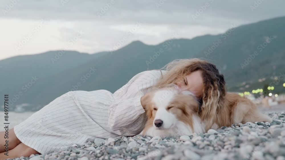 Border collie doggy and woman owner hug caress each other at the sea ...