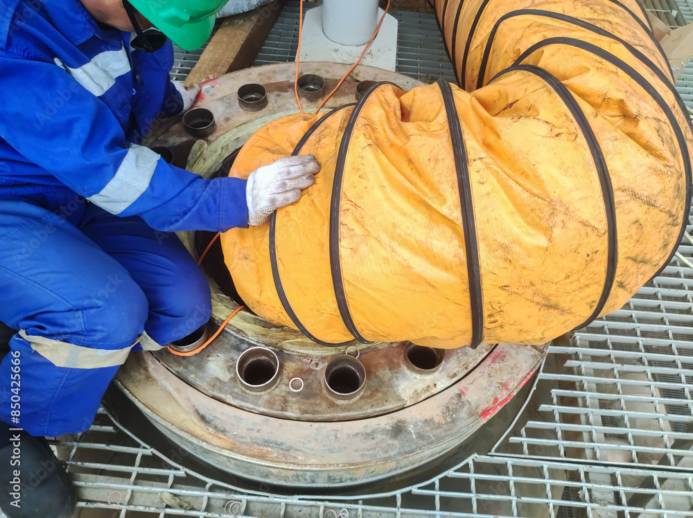man is watching the manhole with an air blower proboscis. concept ...