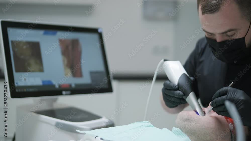 Doctor scans the patient's teeth in the clinic. The dentist holds in ...