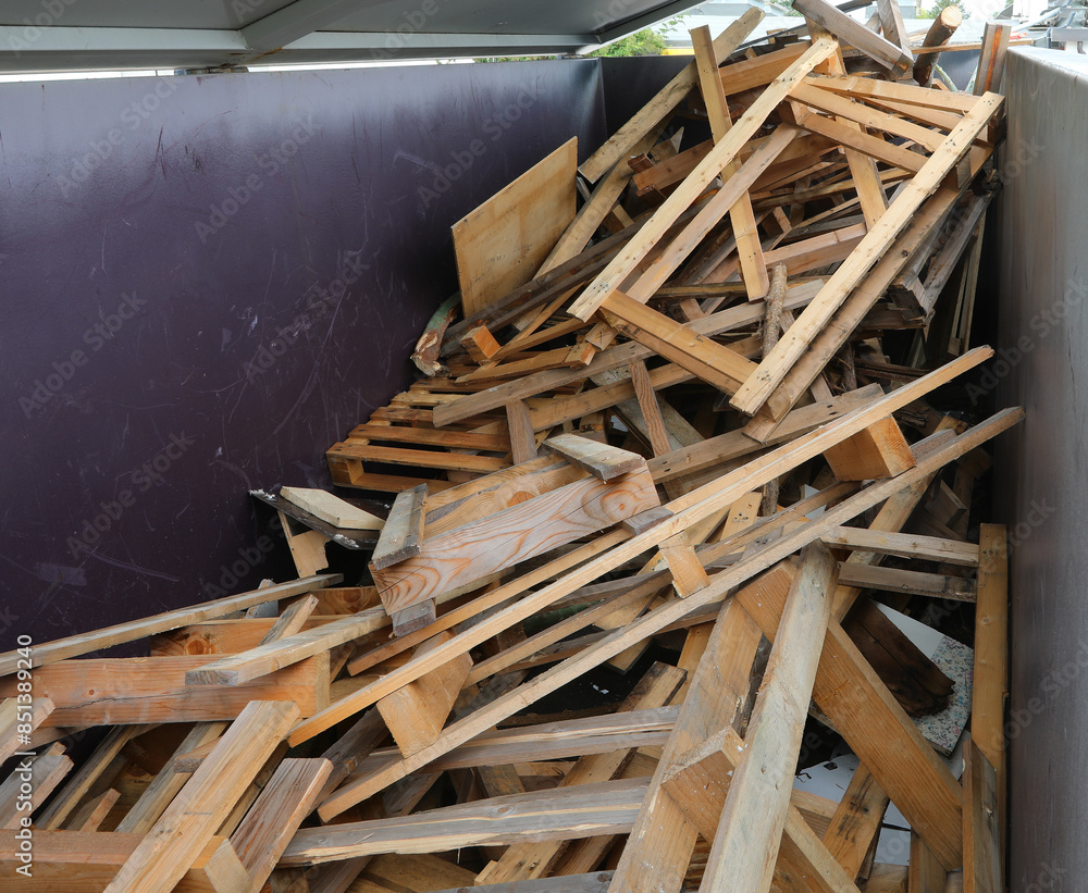wooden pieces planks and broken pallets in the wood recycling container ...