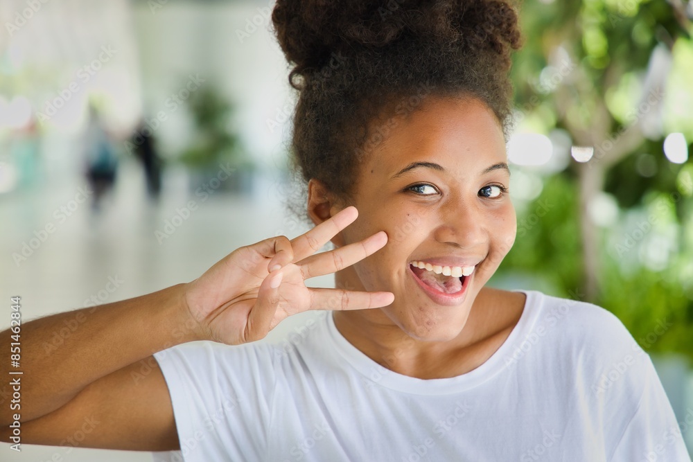 Happy, smiling, friendly African woman in pointing up 3 fingers ...