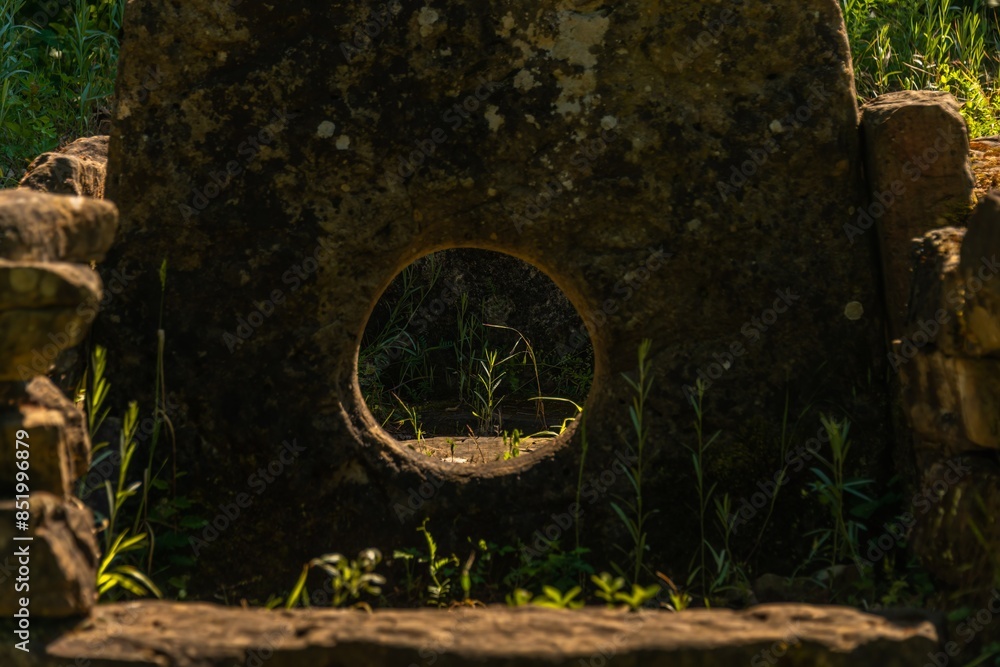 Foto de a round hole in a vertical stone wall of the ruins of an ...