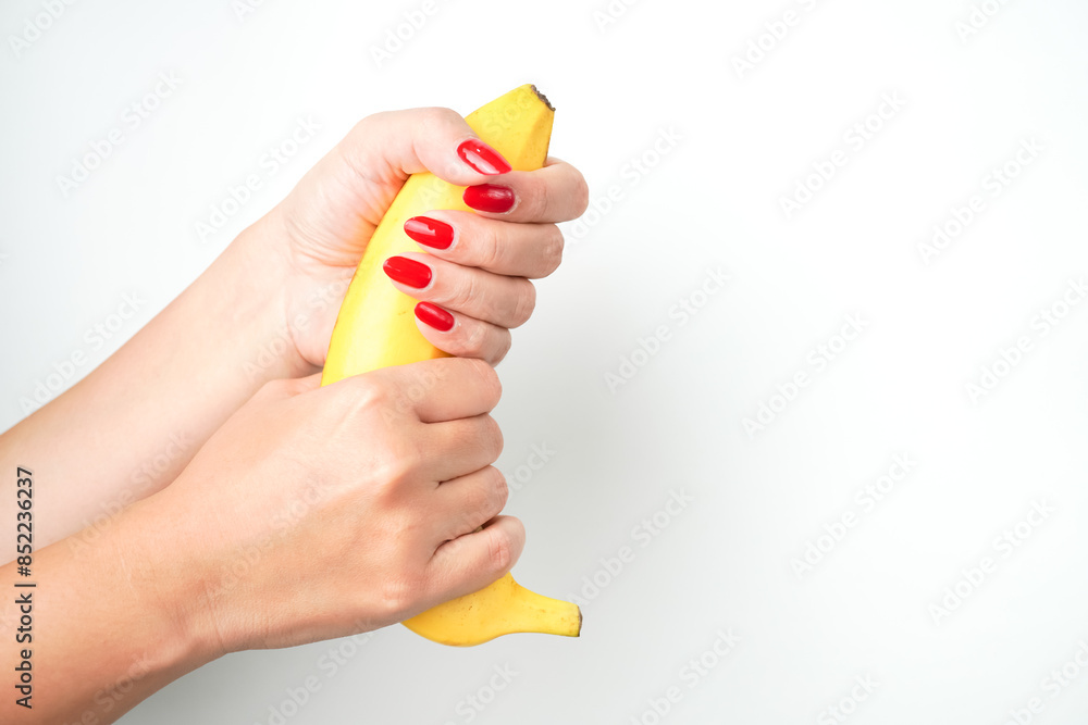 Hands of a woman with bright red nail polish holding large curvy banana ...