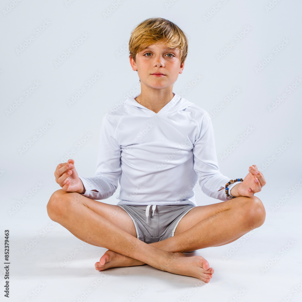 Seated young male child quietly meditating in a Zen like position with ...