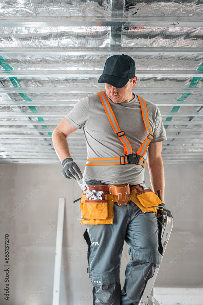Plasterboard worker making a plasterboard ceiling. He is connecting ...