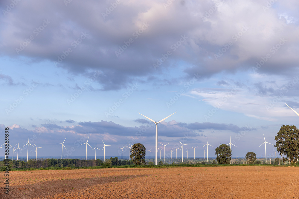 view of wind farm or wind park, with high wind turbines for generation ...