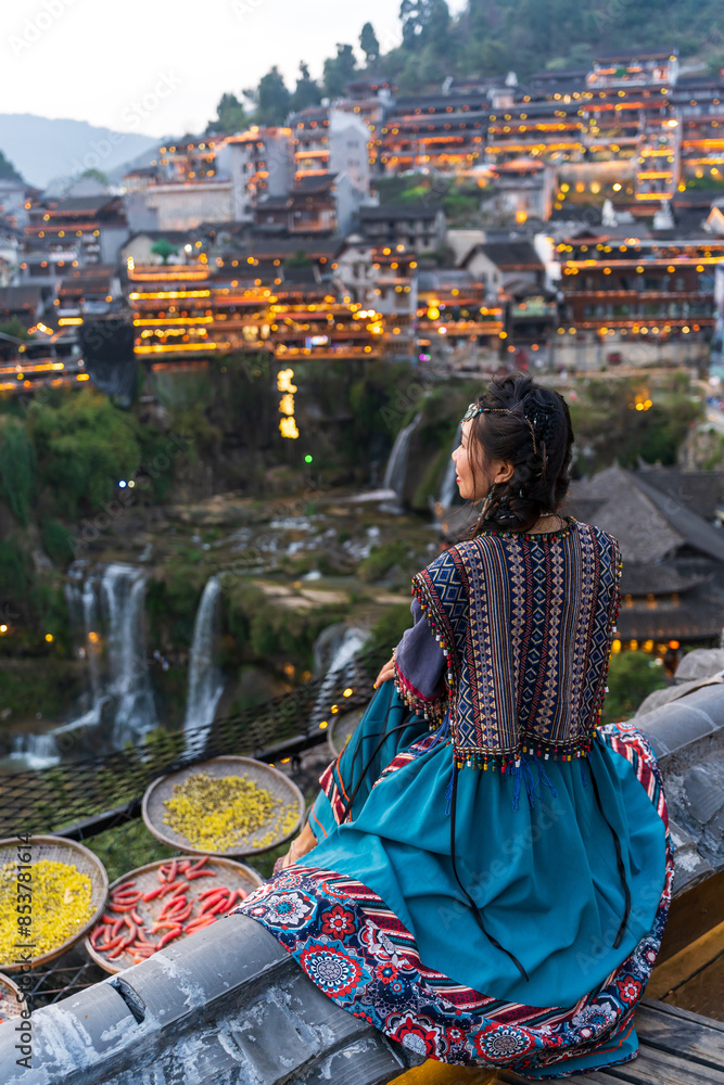 Young female tourist in traditional dress looking at the beautiful ...