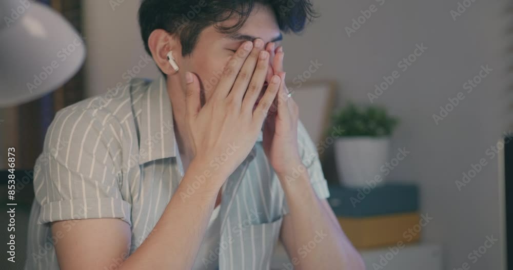 A young man in a moment of emotional stress and fatigue at his home ...