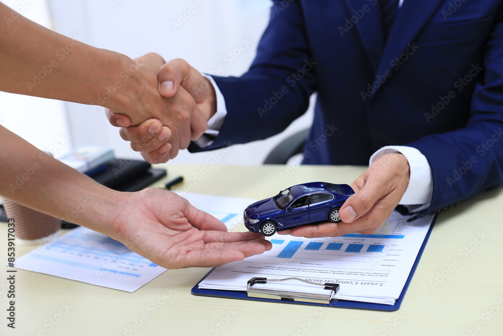 Car insurance documents or rental concept. A car broker helps his ...