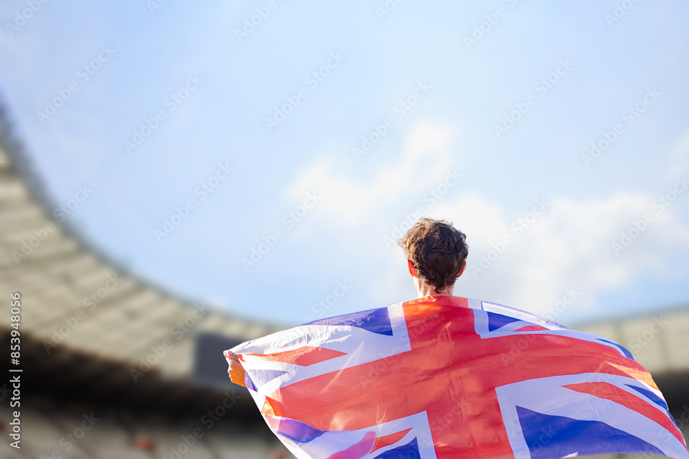 An athlete with the British flag draped over their shoulders ...