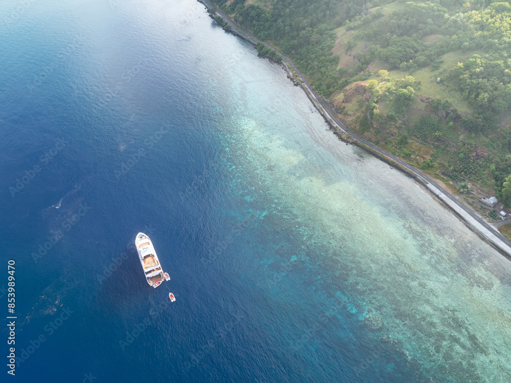 A liveaboard dive boat sits at anchor in the beautiful Pantar Strait ...