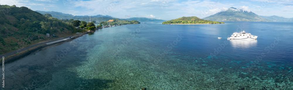 A liveaboard dive boat sits at anchor in the beautiful Pantar Strait ...