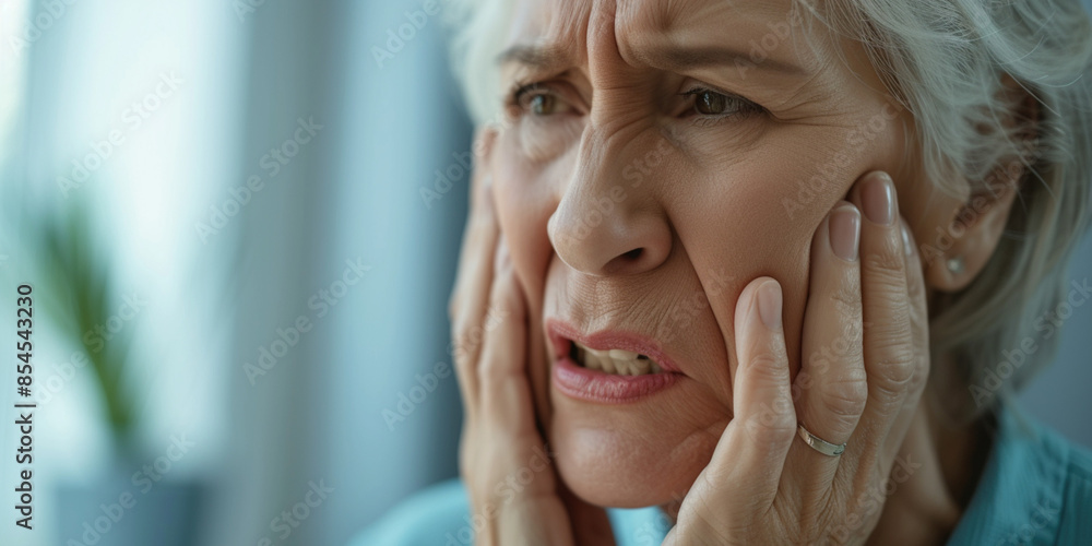 Senior old retired female pressing sore cheek on studio background ...