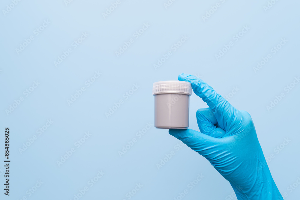 Hands in blue glove holding stool container sterile sample specimen ...