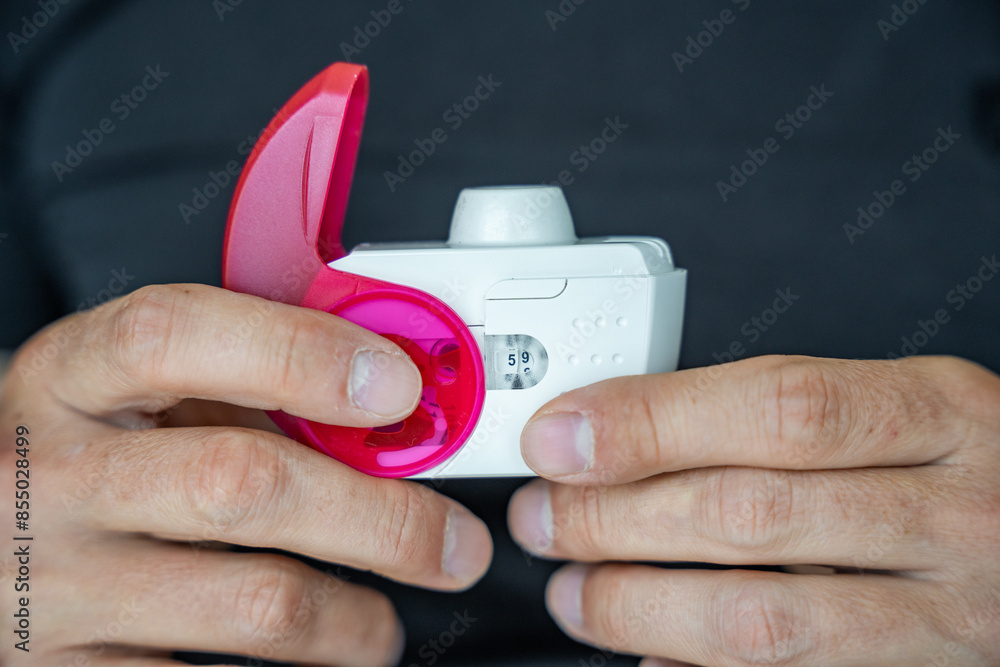 Close up view of man using medicine dry powder inhaler for treatment ...