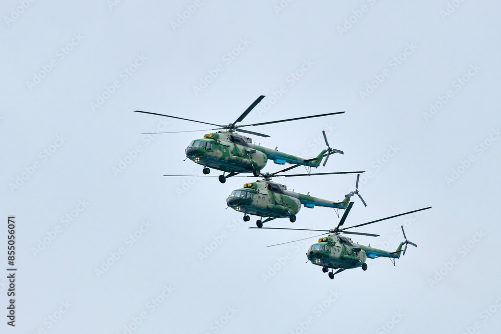 Three Russian military helicopters armed with missiles flies in blue ...