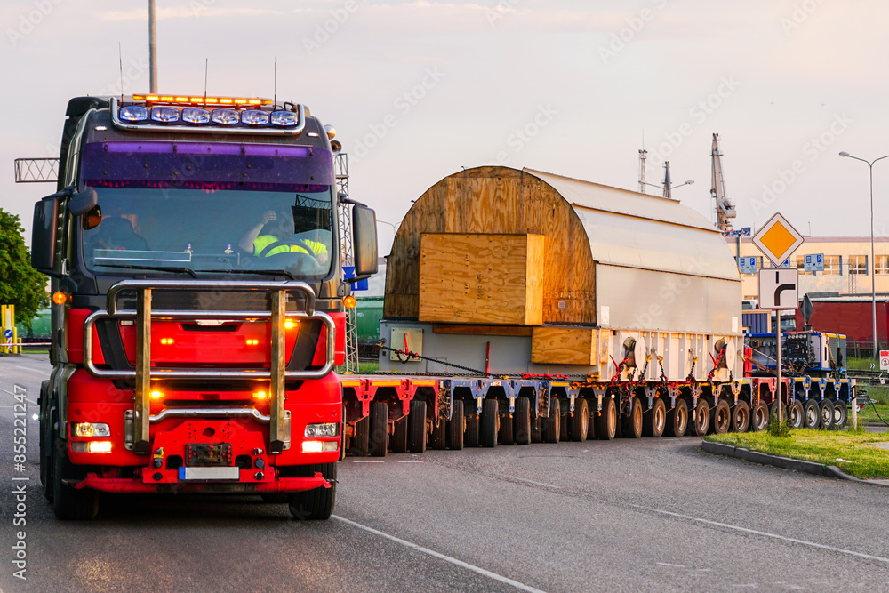 Truck with a very long specialized multi-axle trailer carries a very ...