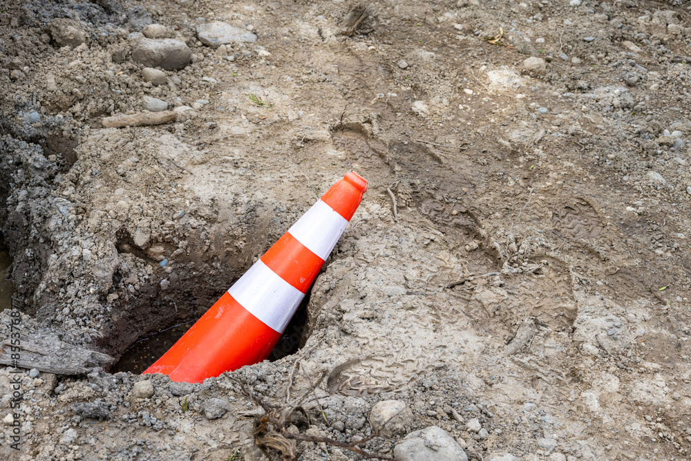Construction job site safety, hole in dirt with orange safety cone to ...