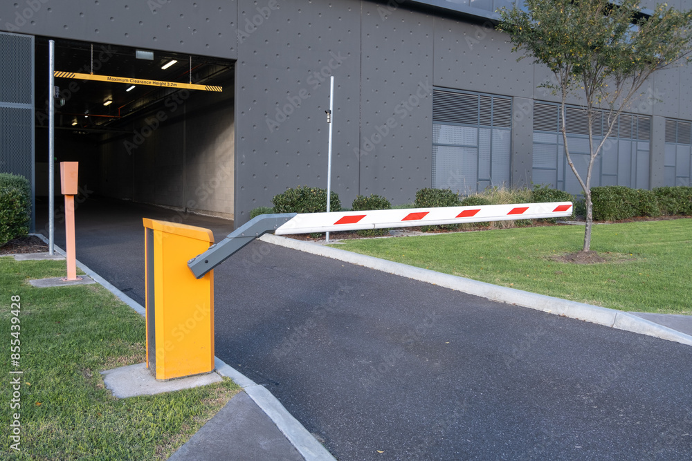 At the entrance of an indoor parking garage, a closed automatic barrier ...