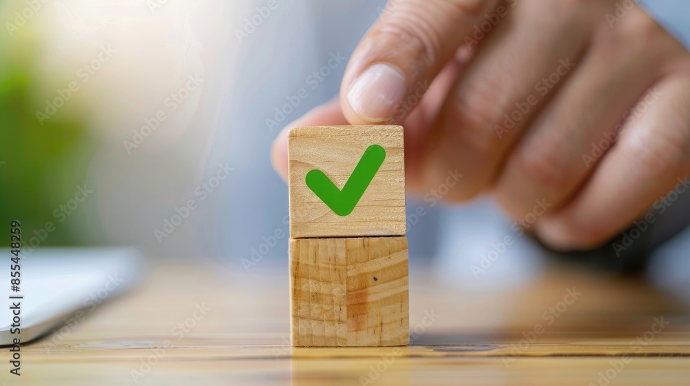 Wooden blocks checklist and green check mark icon with hand on table ...