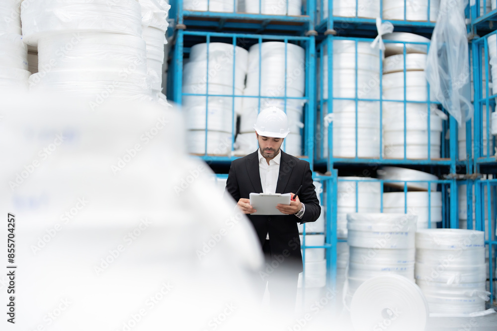 The factory personnel, a European male engineer, looked at the product ...