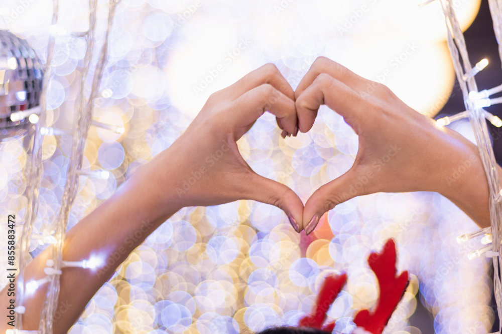 woman raises her hands to make heart symbol that represents love and ...