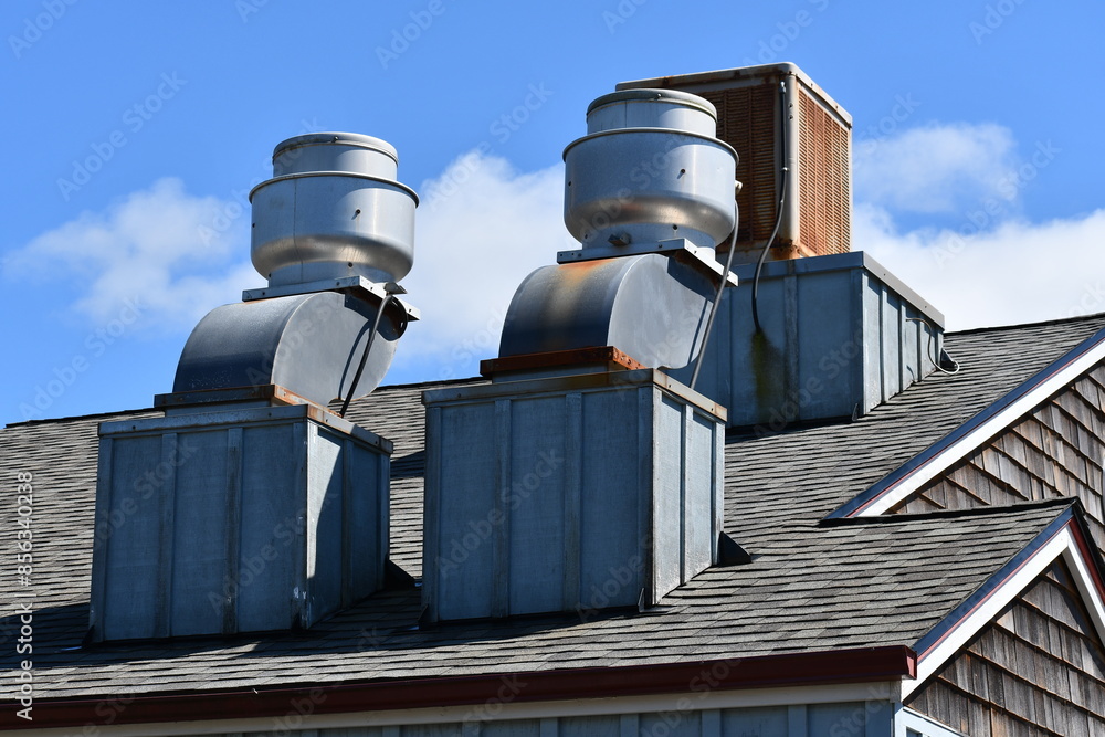 Two large industrial kitchen vents, rooftop mounted with aged HVAC ...