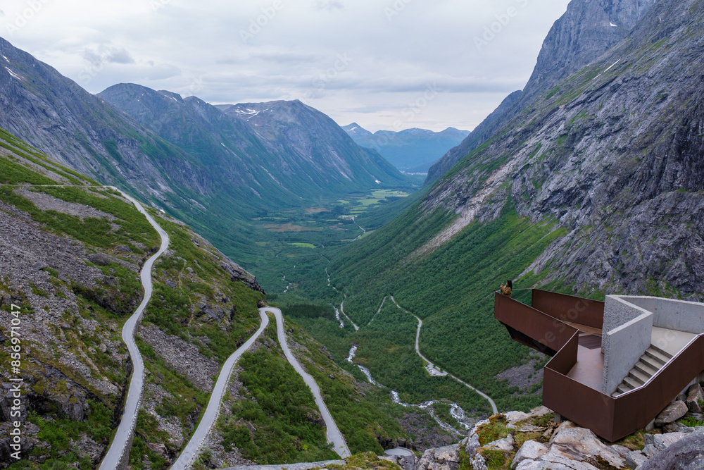 A winding road snakes through the verdant Norwegian mountains, with a ...