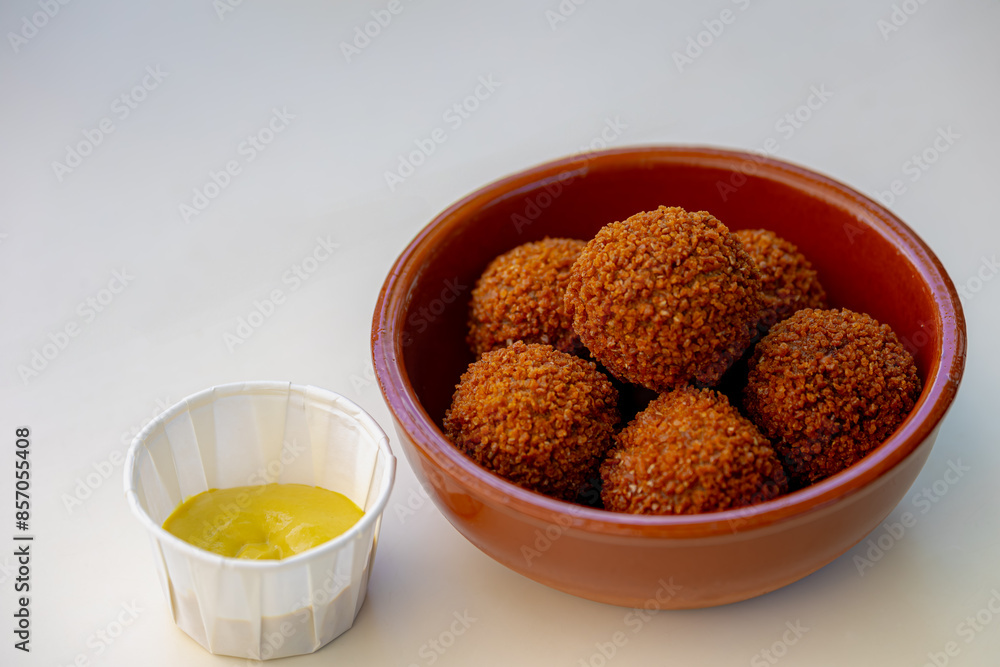 Bitterballen, Dutch meat-based snack in brown bowl served with yellow ...