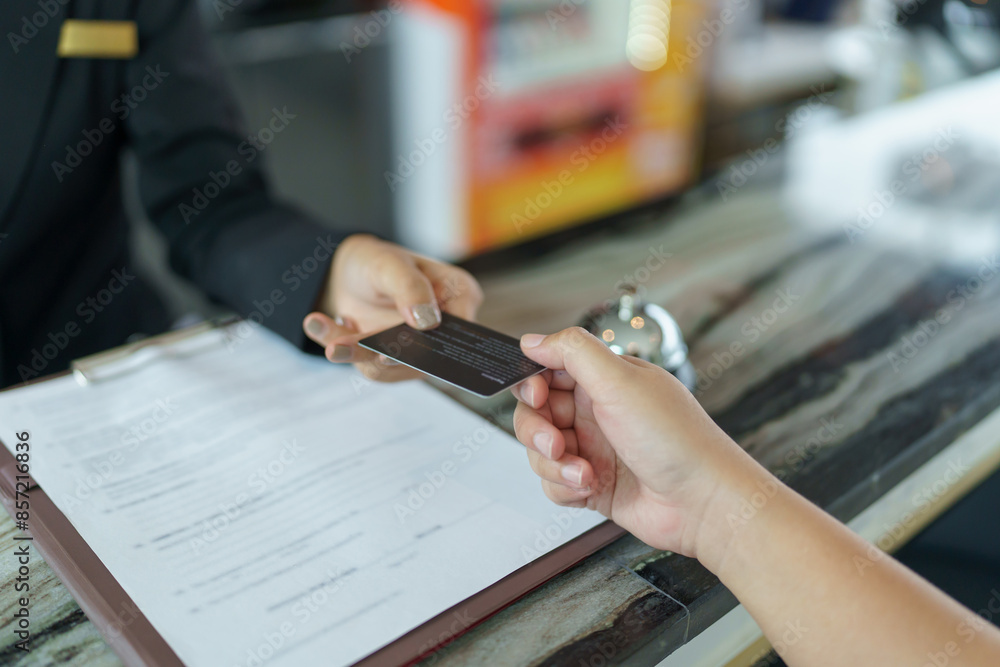 Hotel receptionist in uniforms Concierge giving the key doing check-in ...
