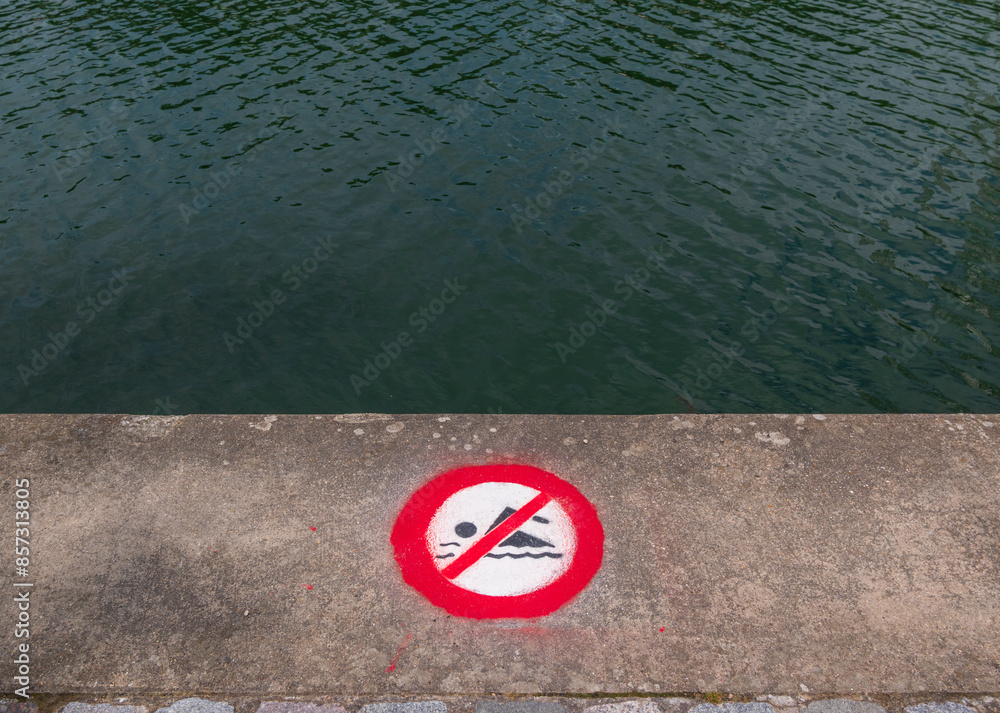 Panneau d'interdiction de baignade, au sol, le long du bassin de La ...