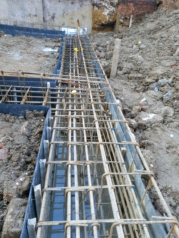 Strip foundation with rebar reinforcement in construction site. Vertical shot for structural ...