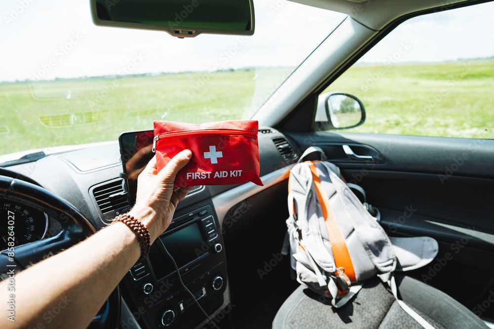 In a car, a person is equipped with a first aid kit. The vehicle ...