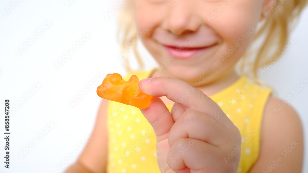 cheerful small child holds sweets, blonde girl 3 years old wants eat ...