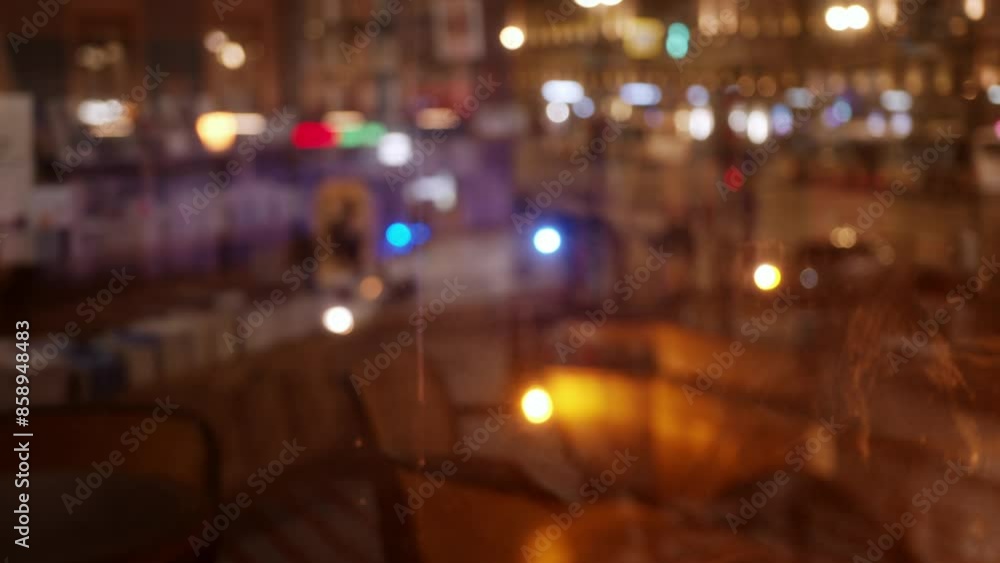 Blurred lights of evening city through window of building. Public ...