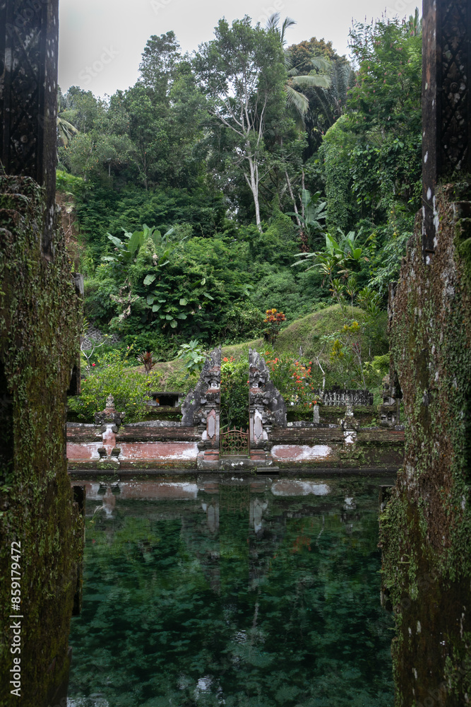 Bali gate (aka Candi bentar) surrounded by green mystical waters. Split ...