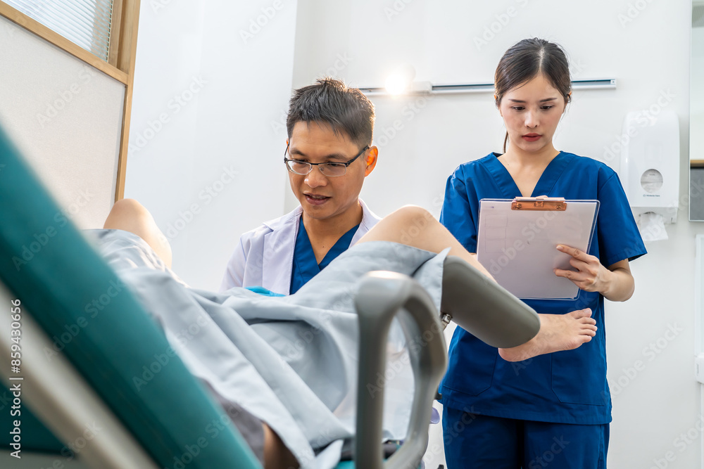 Male asian doctor doing internal examination on female patient at ...