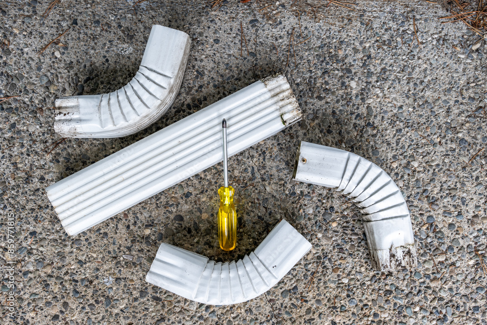 Sections of rectangular metal downspout drain pipe taken apart to clean out clogs blocking water ...