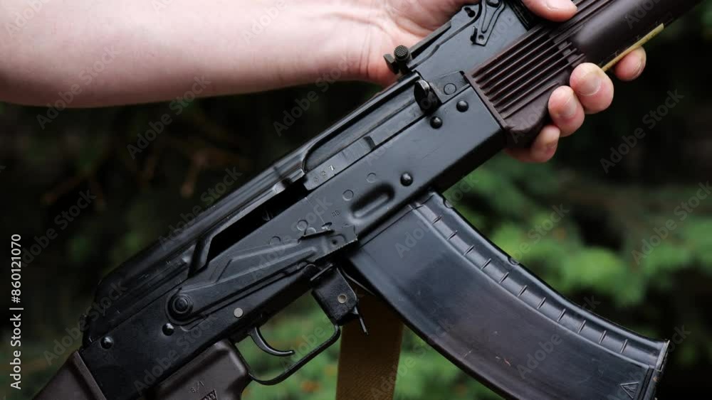 a man in a wax uniform sends a cartridge into a machine gun, loading a ...