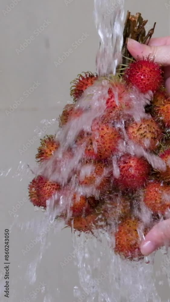 Cascading water over a sink full of vivid rambutans, showcasing the ...