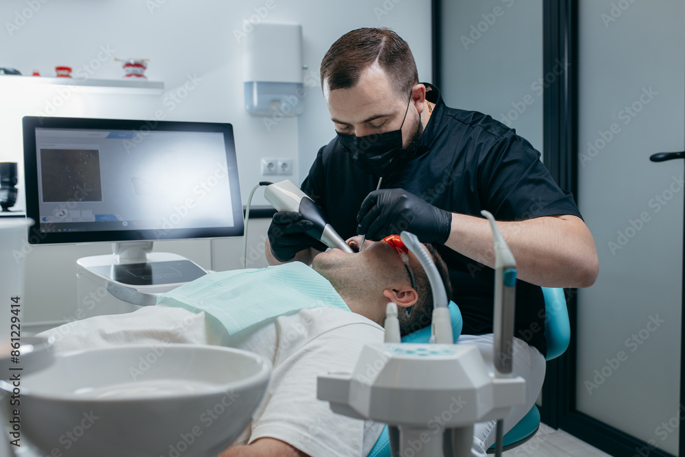 Dentist scanning teeth of male patient with modern scanning 3d machine ...