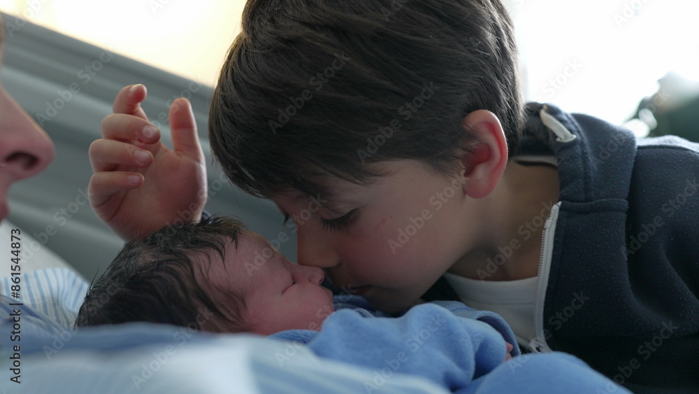 Young boy meeting his newborn baby brother for the first time at ...