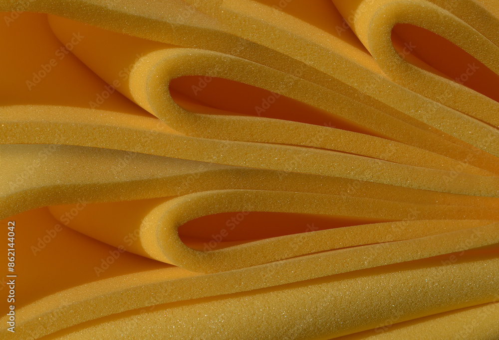 curved folds of yellow sponge foam sheet. springy, elastic, textured ...