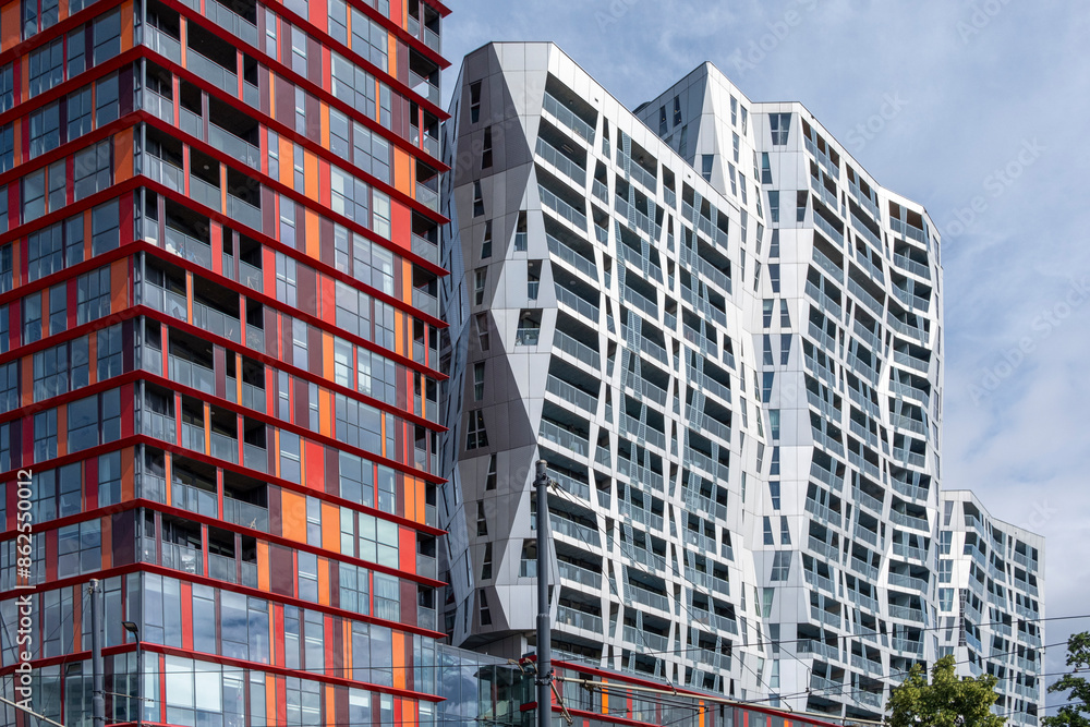 This image depicts modern high-rise buildings with striking red and ...