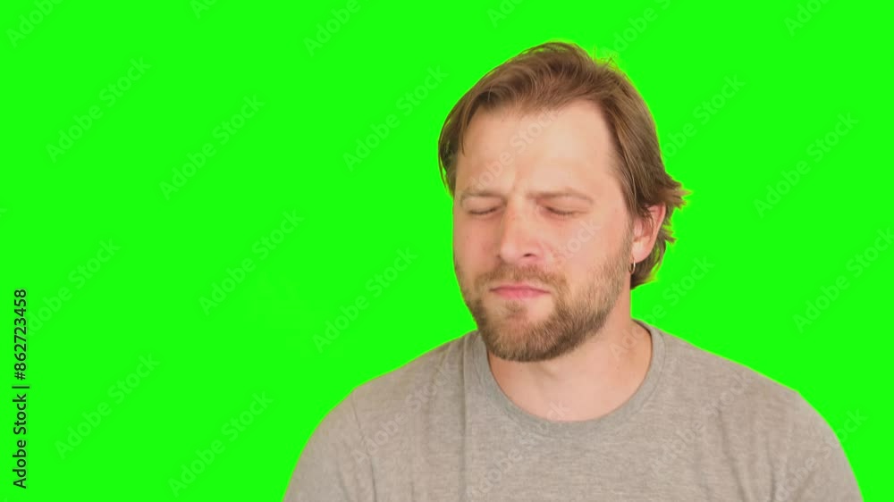 Upset man over plain green background. Adult bearded fun confused shy ...