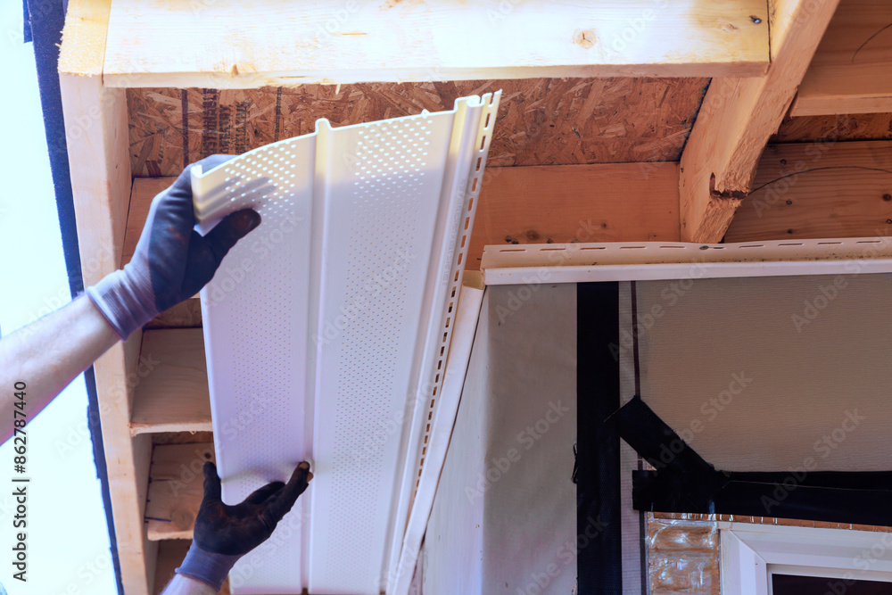 Nailing upvc soffit boards to roof rafters on ceiling house Stock Photo ...